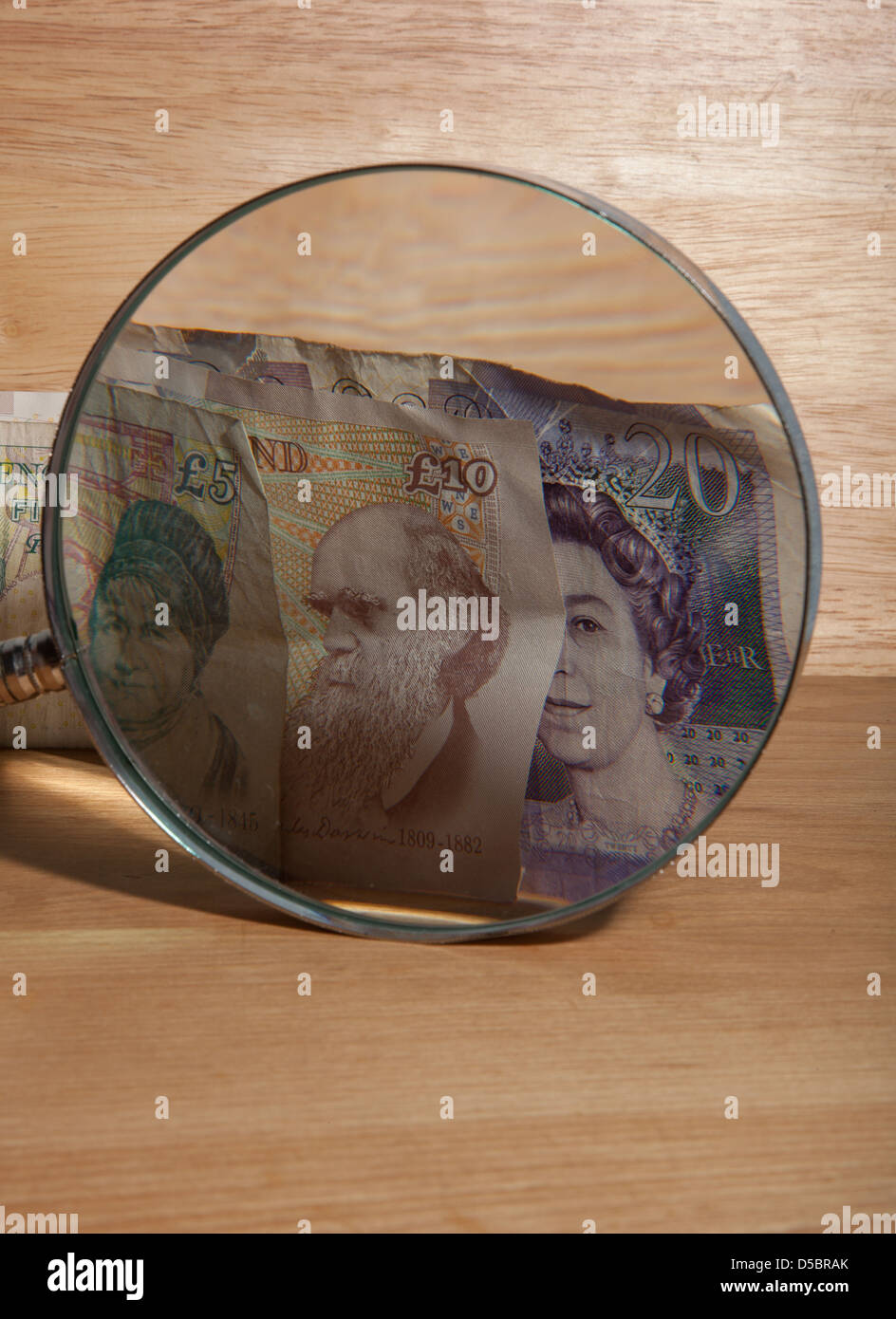 UK banknotes seen through a magnifying glass. Concept of growth or ...