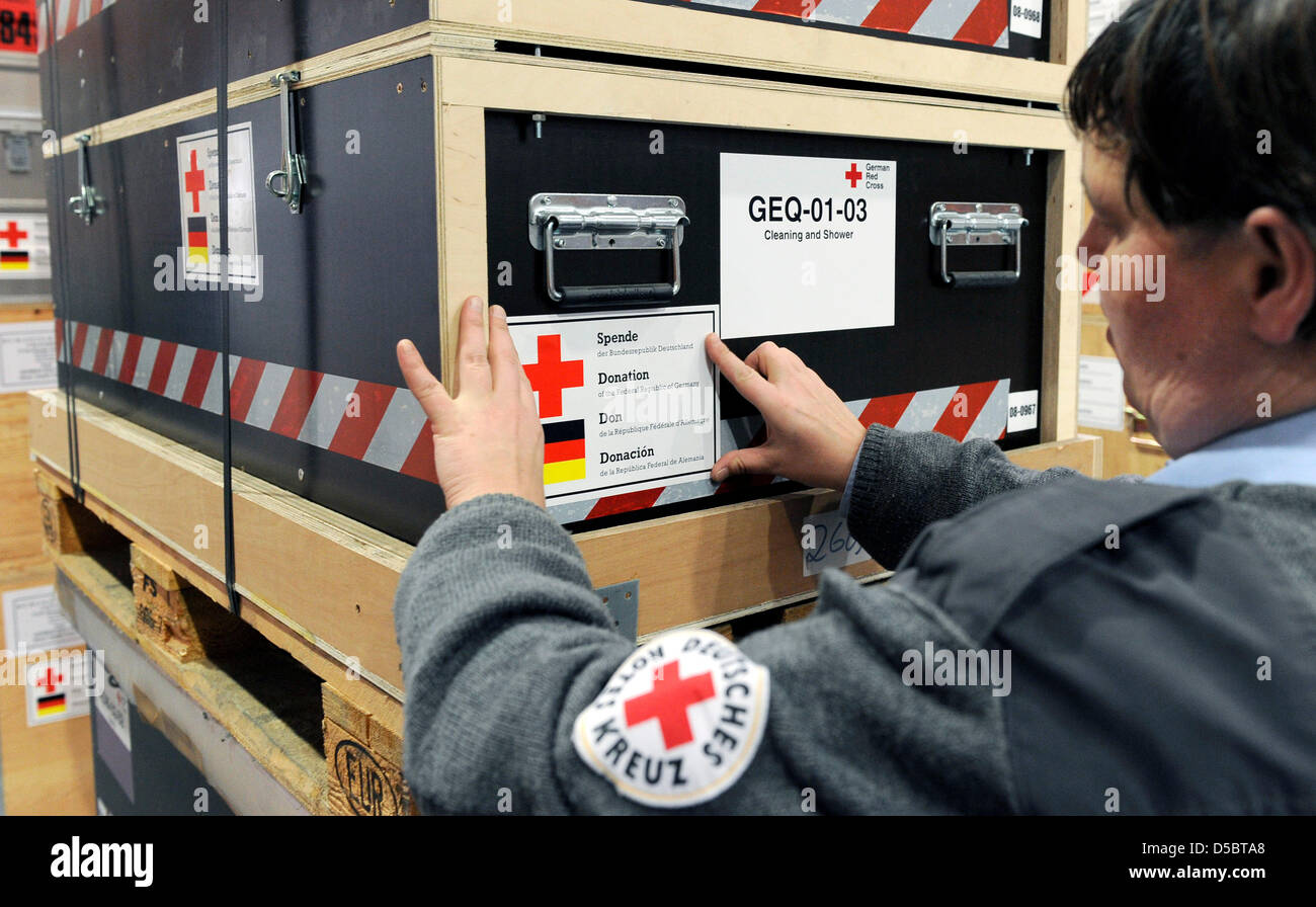 A helper of the German Red Cross labels boxes at the logistics centre ...