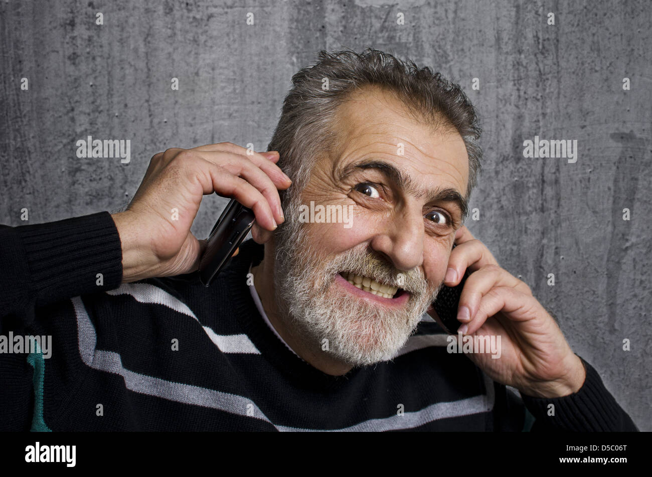 Portrait of Angry Stressed Businessman with two cell phones on grunge ...