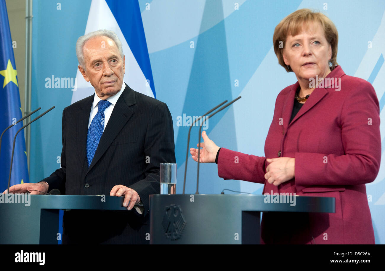 German Chancellor Angela Merkel and Israeli President Shimon Peres give ...