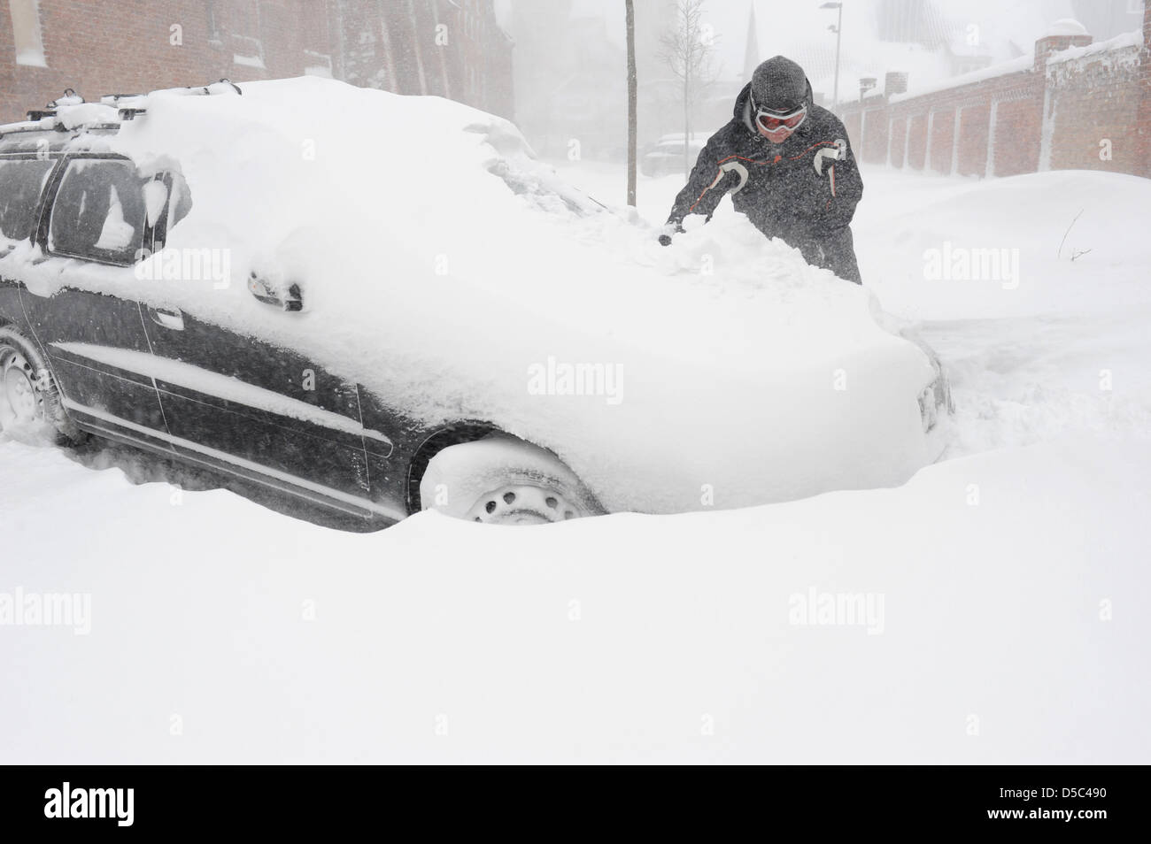 A man tries to clear his car of the snow in Stralsund, Germany, 30 ...
