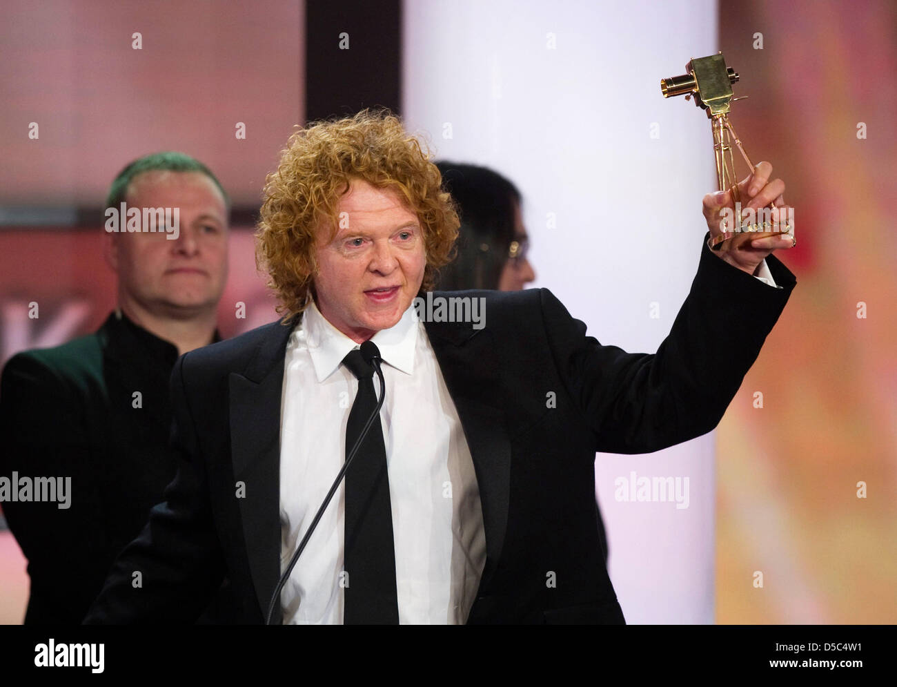 British singer Mick Hucknall (C) of Simply Red accepts his award ...