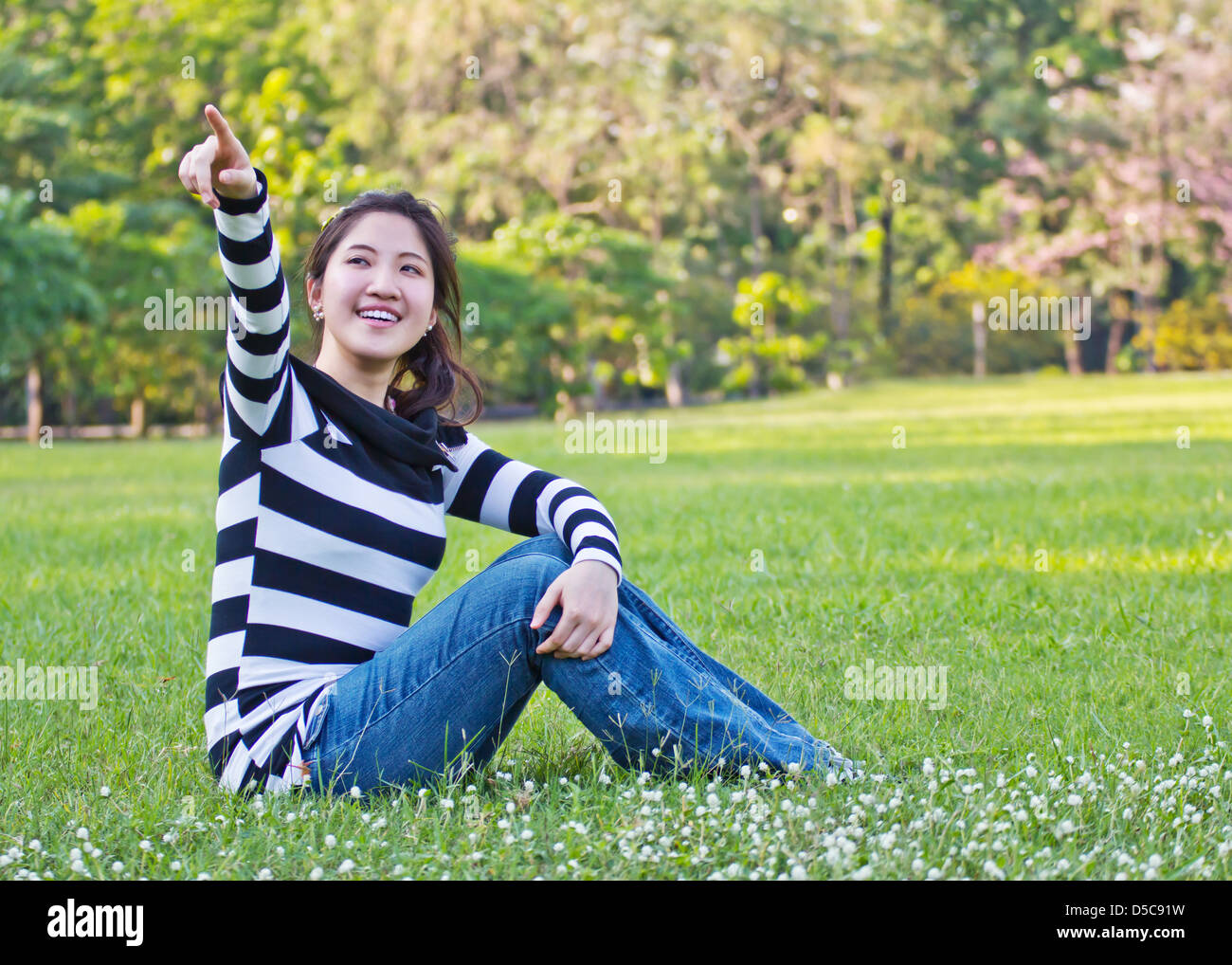 Asian woman pointing the tree Stock Photo - Alamy