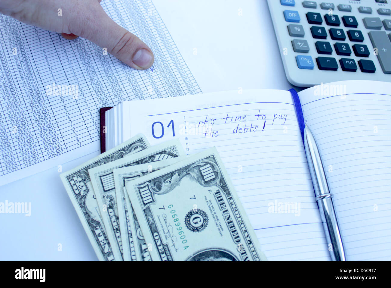 writing down in a notebook about a debt and denominations of dollars ...