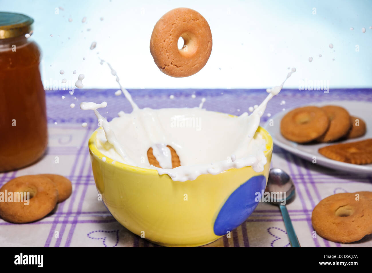 Two biscuits falling down in a cup of milk Stock Photo - Alamy