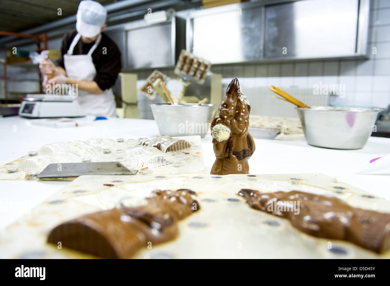A chocolate Easter bunny couple stand on a table in the workshop of the ...