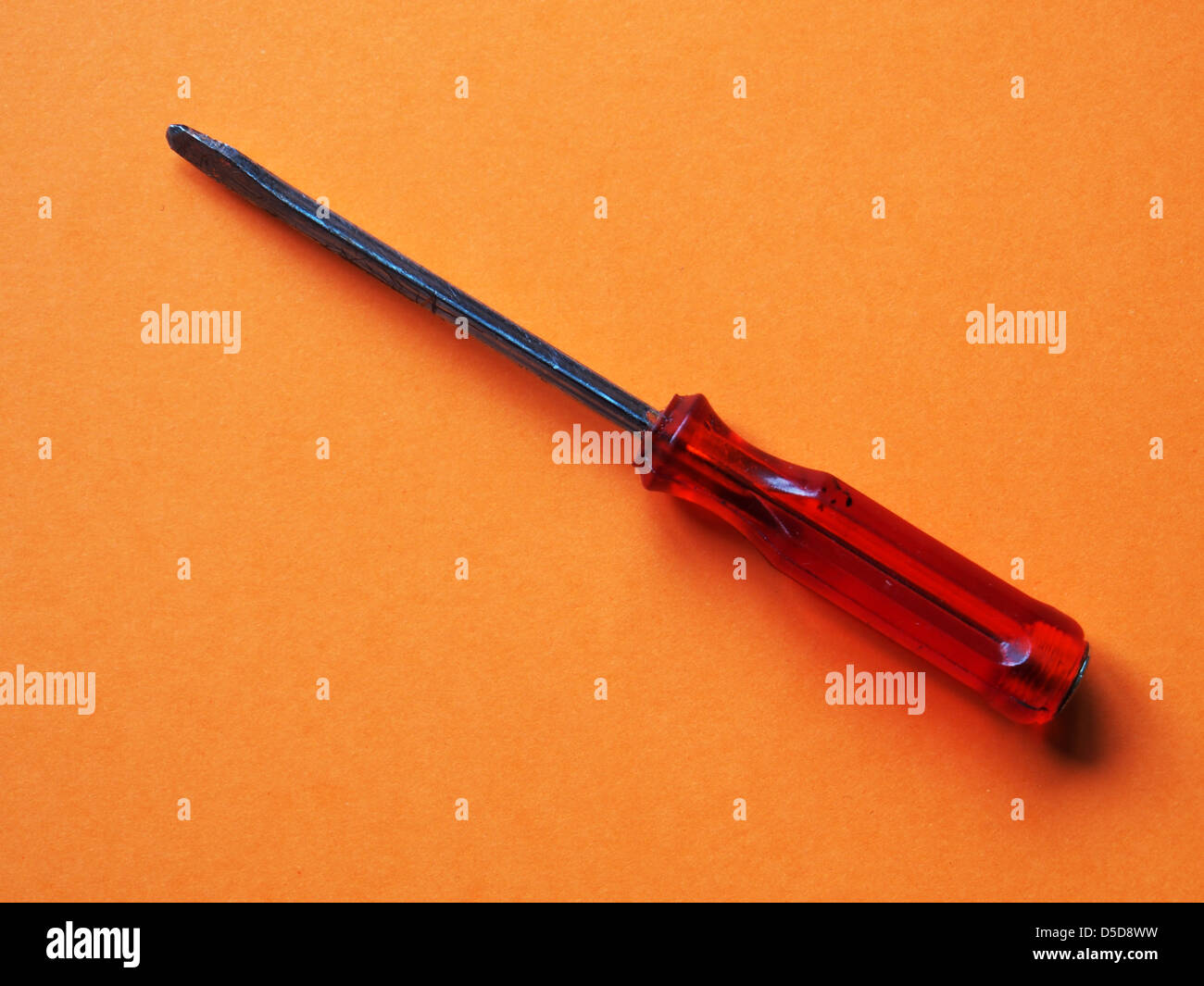 screwdriver with red transparent handle on an orange background Stock ...