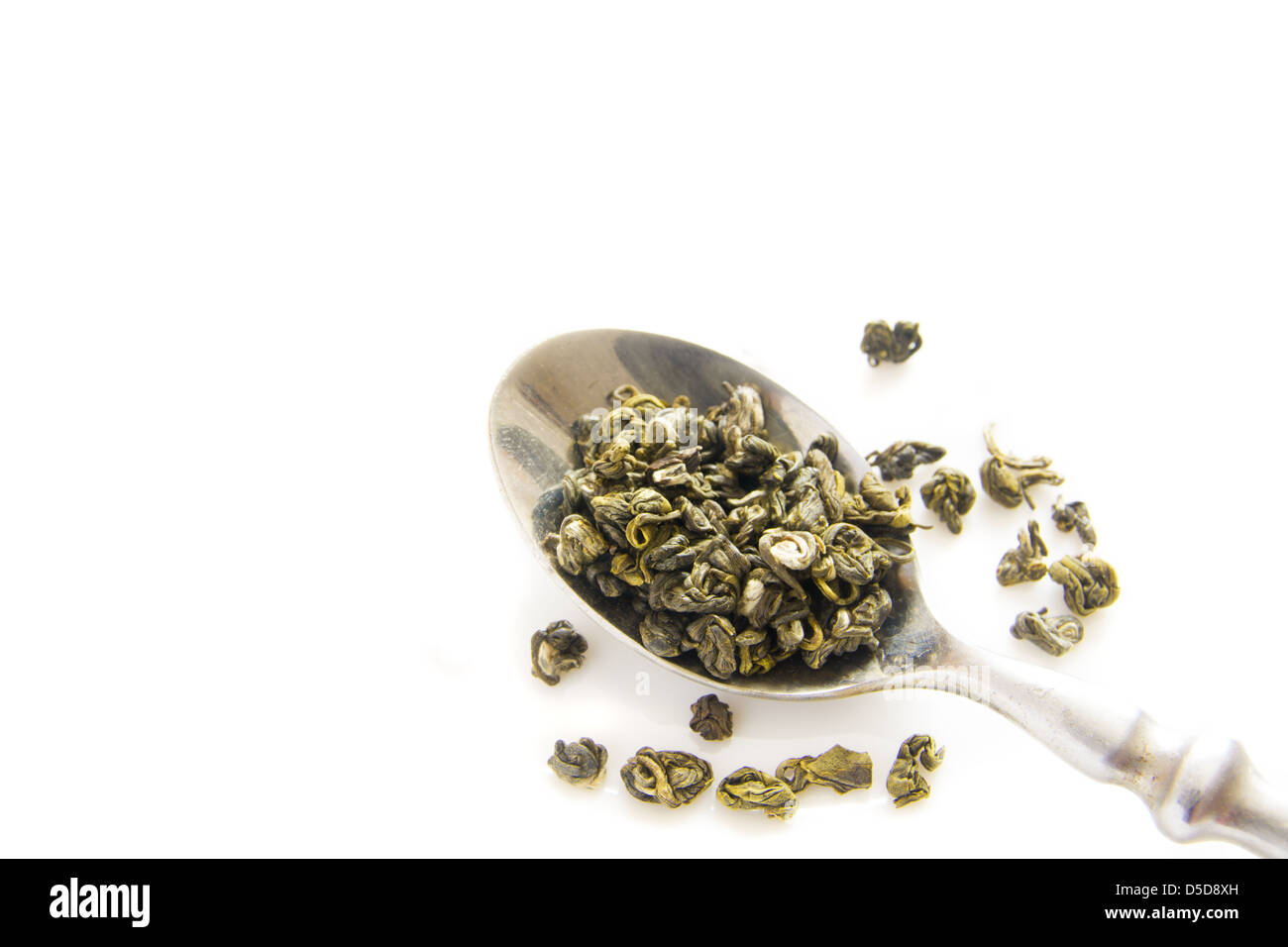 Heap of green tea with spoon close up isolated on white background ...
