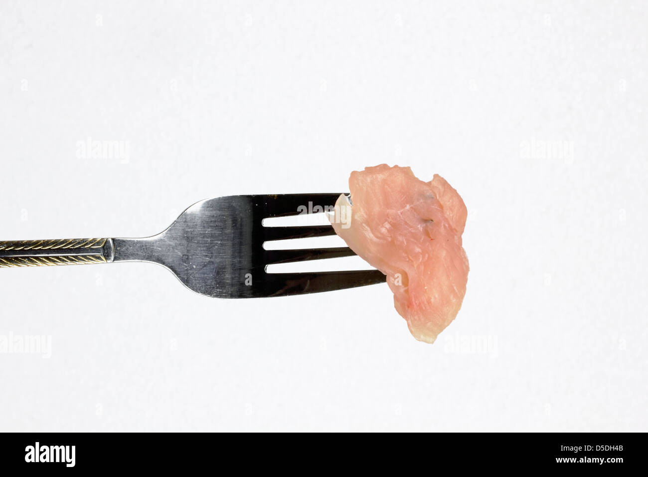 raw chicken on the fork on the white background Stock Photo - Alamy
