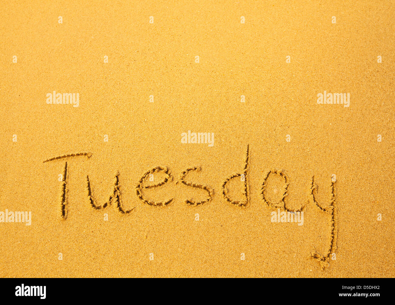 Tuesday, written in sand on beach texture Stock Photo - Alamy