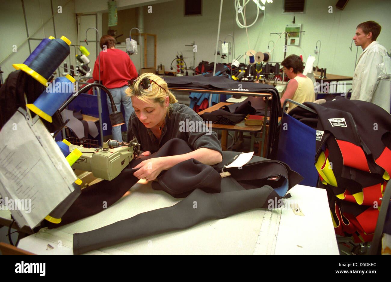 A machinist stitching together a wetsuit Stock Photo - Alamy