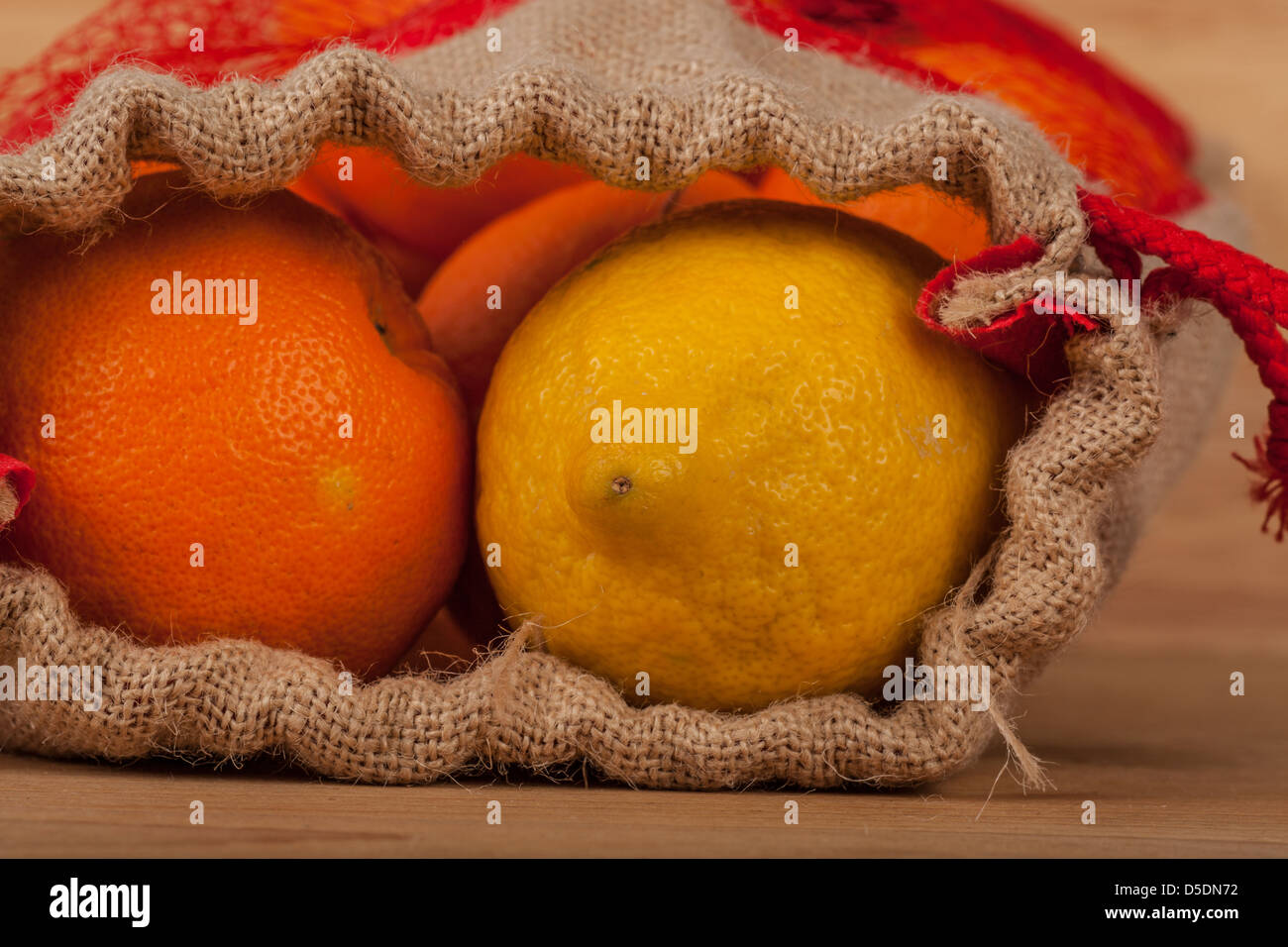 Oranges and a lemon in a small jute sack Stock Photo - Alamy