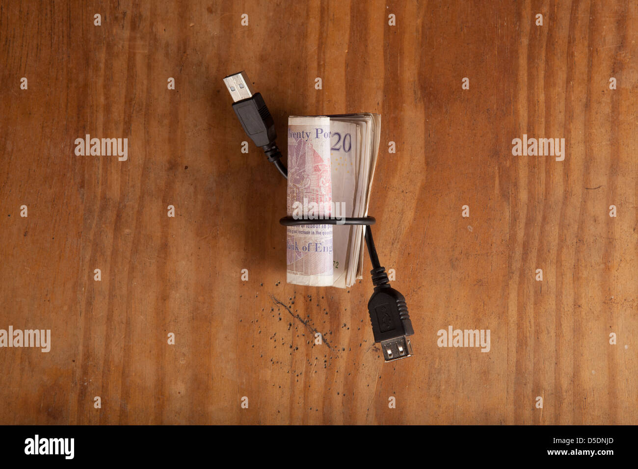 USB cable tied around a roll of UK banknotes Stock Photo - Alamy