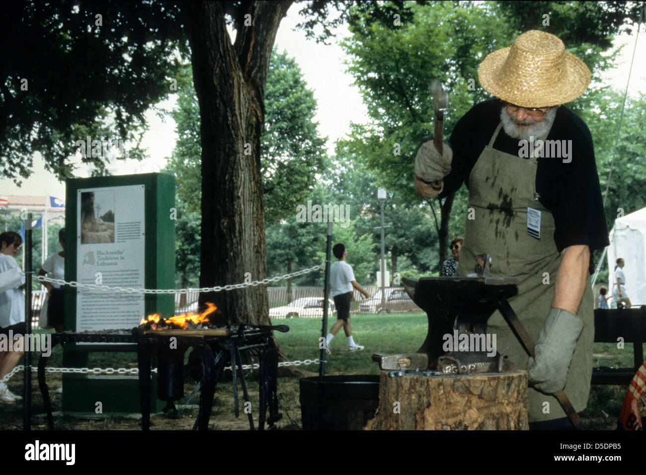 A craftsman works with an anvil in Lithuania at a cultural event ...