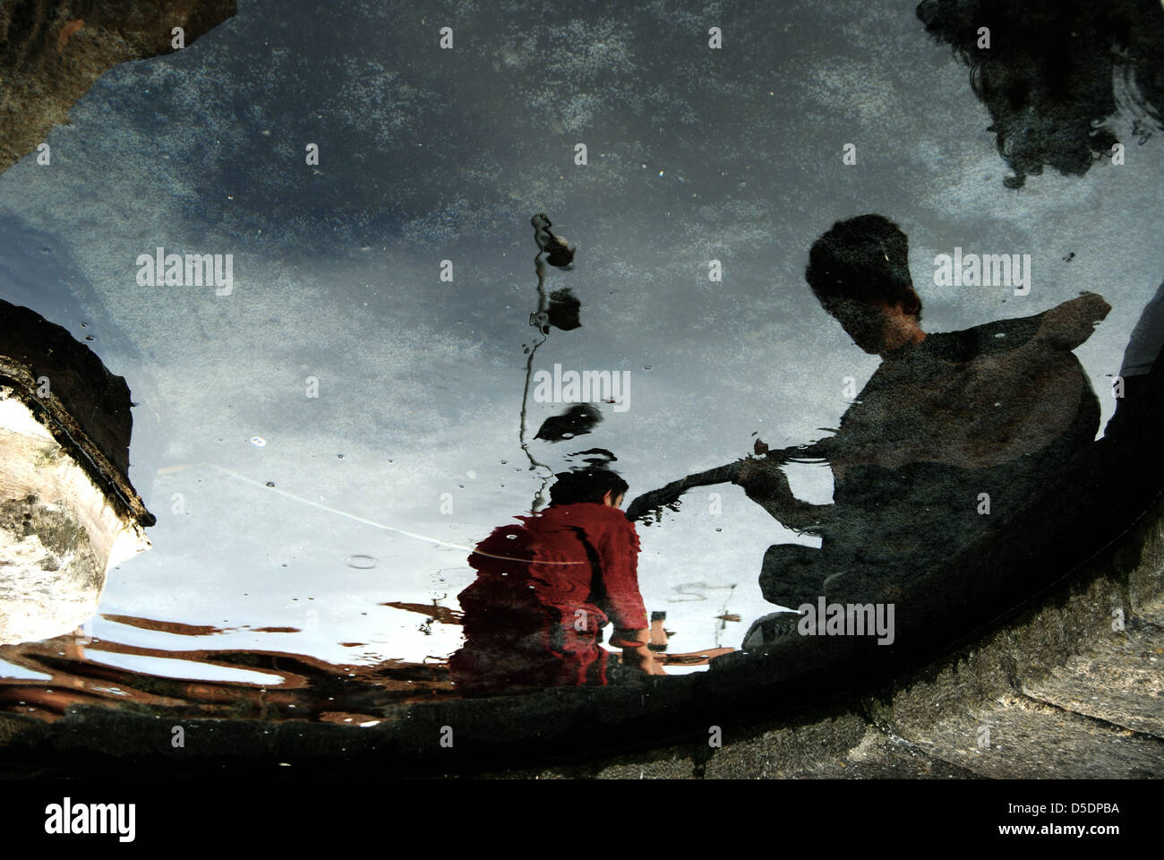 Reflection of two people in a fountain Stock Photo - Alamy