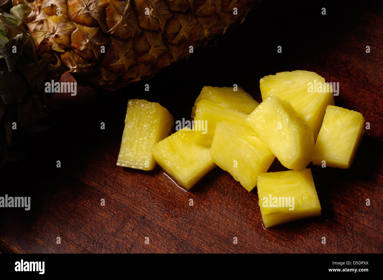 Fresh pineapple chunks on wooden chopping board Stock Photo - Alamy