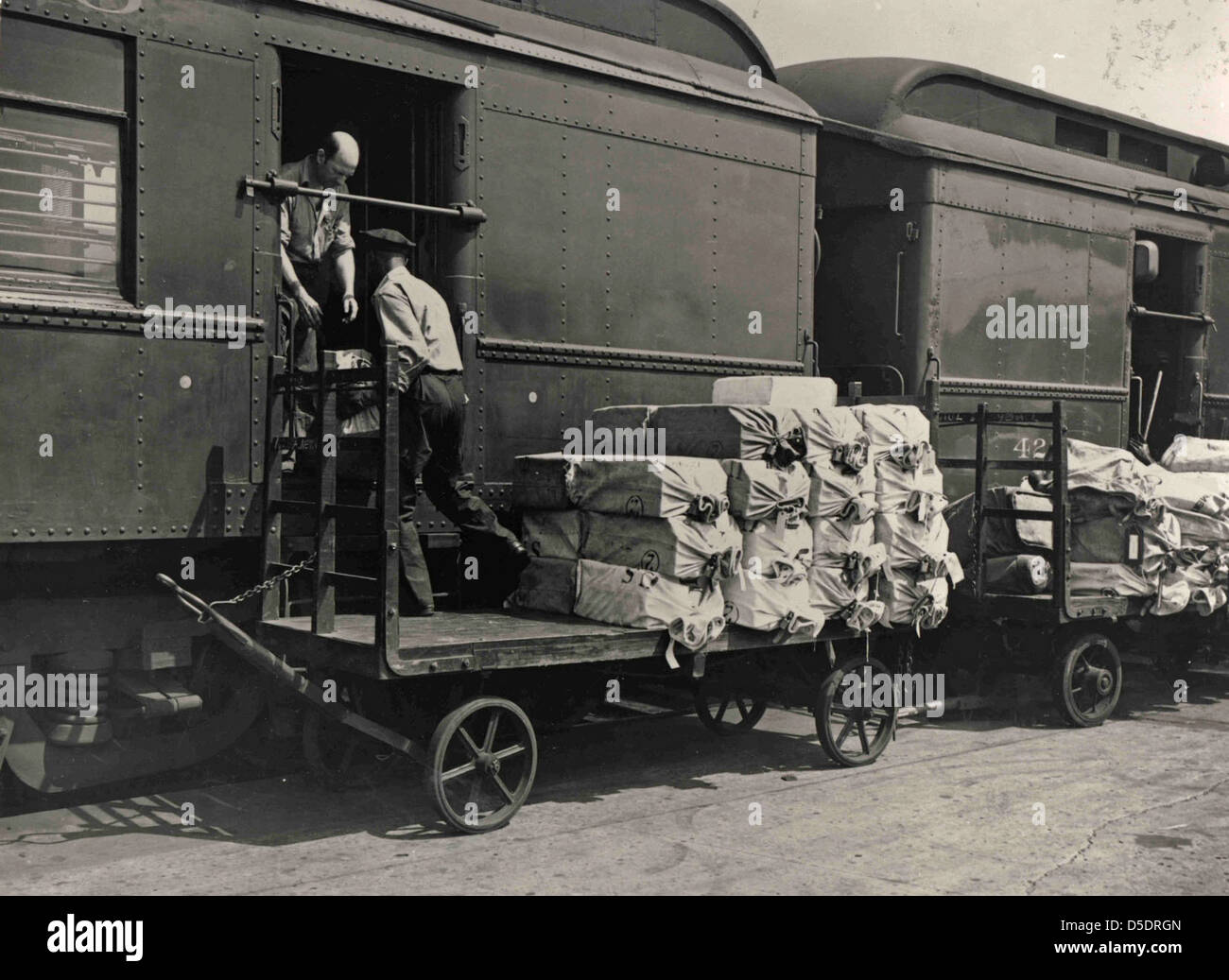 A black-and-white photograph capturing mail being loaded onto a Railway ...