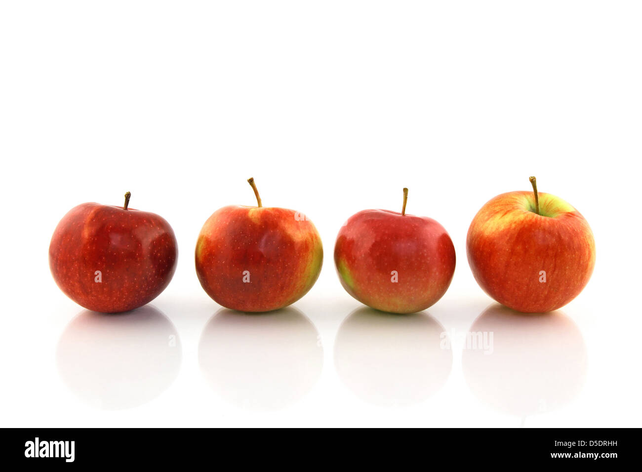 Four red apples in a row, reflecting on white background Stock Photo ...