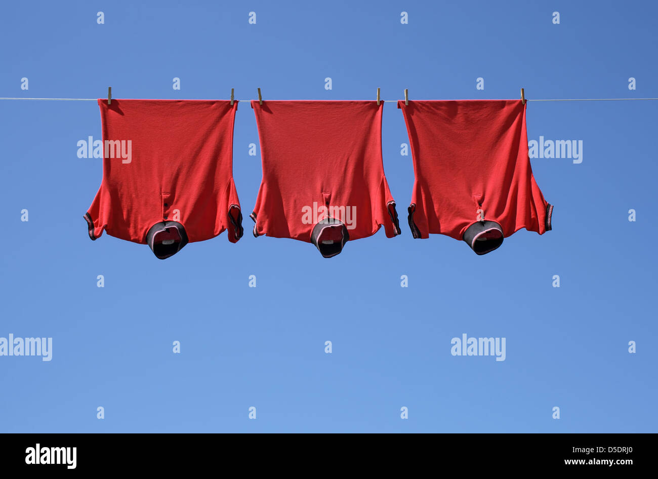 Laundry, three red t-shirts on a clothes-line Stock Photo - Alamy