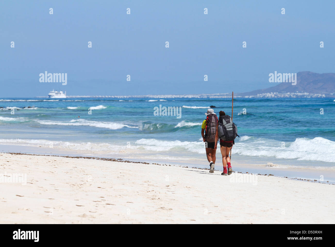 Backpackers walking on the beach. Fuerteventura, Canary Islands Stock ...