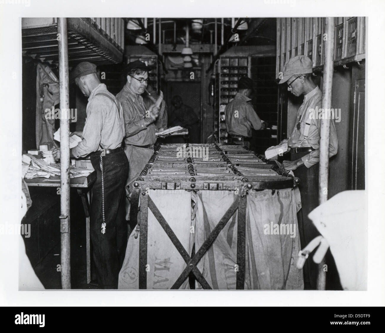 This image shows clerks sorting mail in a Railway Post Office car in ...