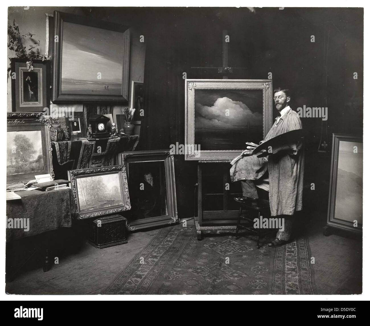 A black and white photo of male artist Leon Dabo at an easel ...