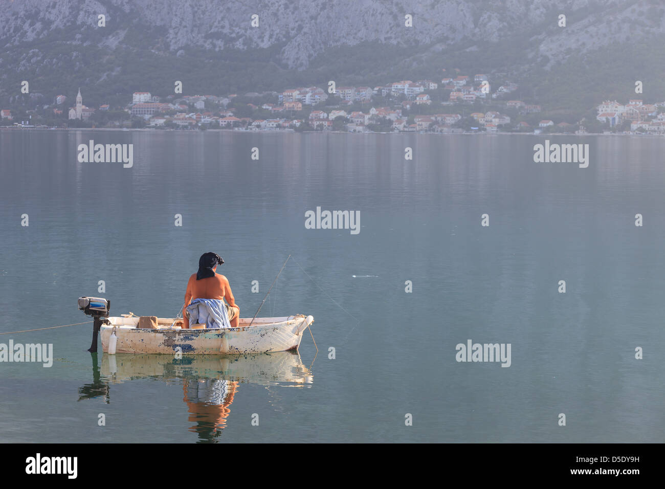Man relaxed fishing in a small boat on Kotor Bay Montenegro Stock Photo ...