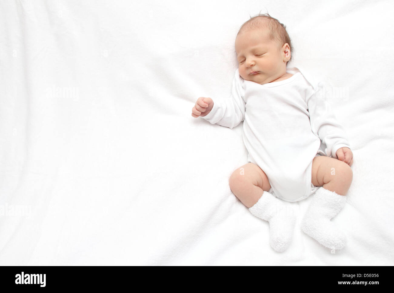 Sleeping baby on back on white bed Stock Photo - Alamy