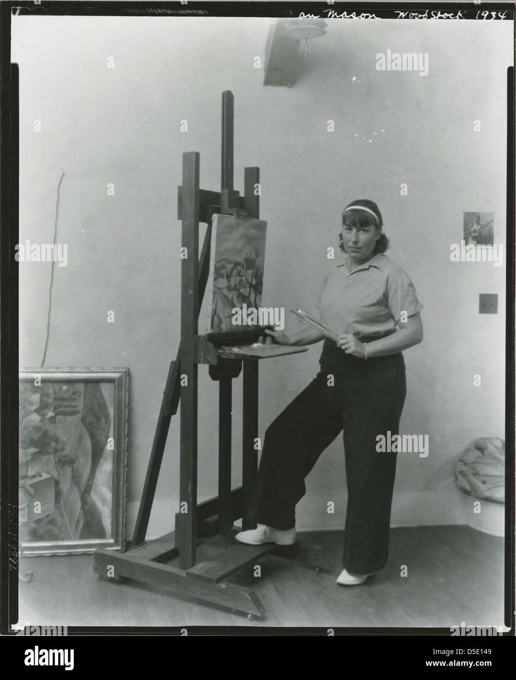 A photograph of Nan Mason, an American painter, working in her studio ...