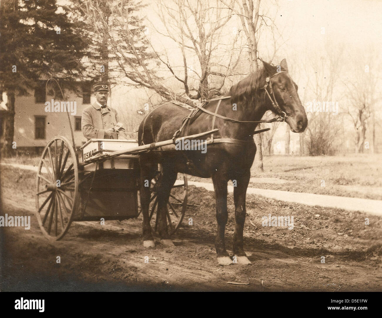 A photograph showing a letter carrier on a horse-drawn wagon. The image ...