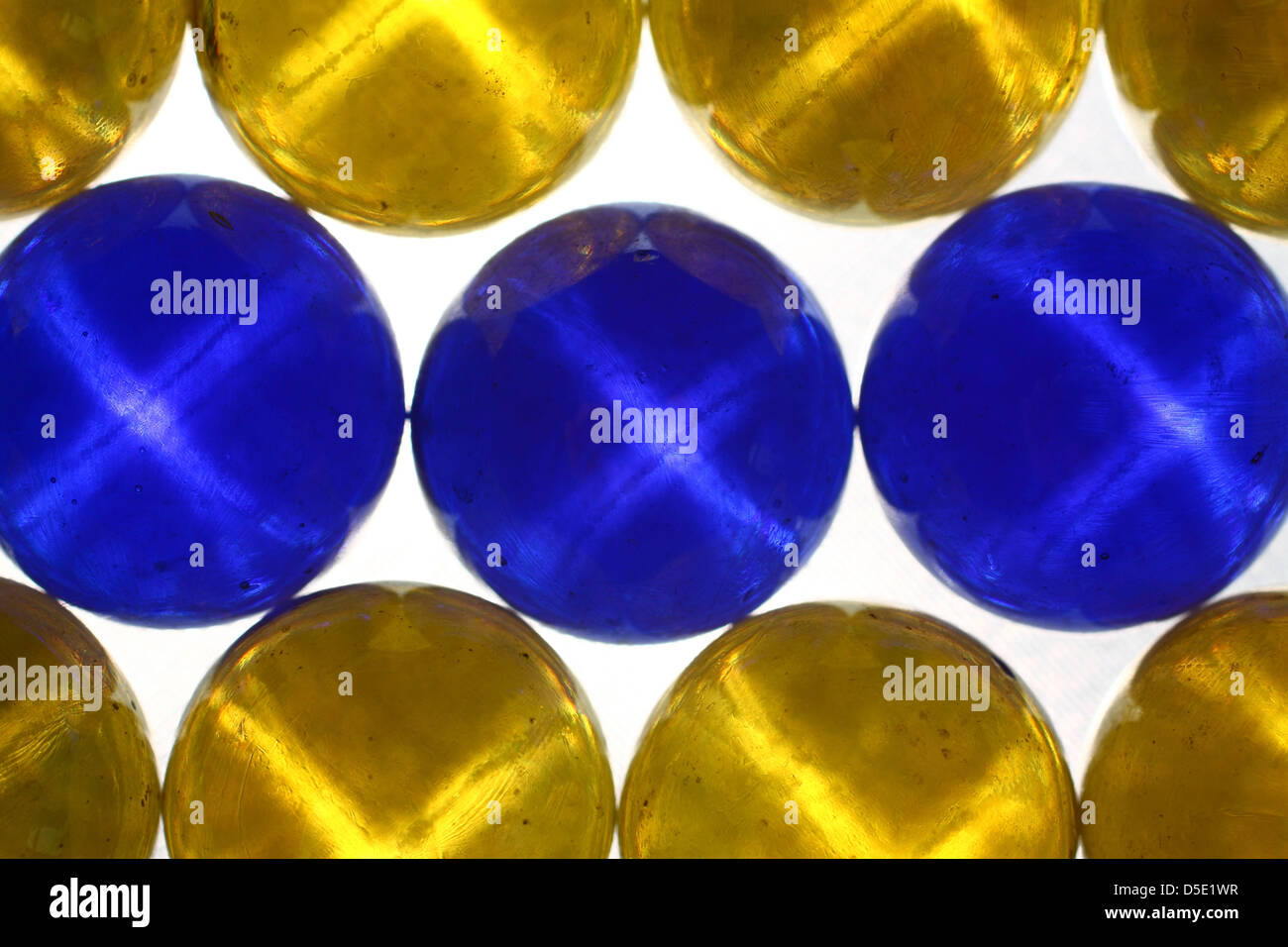 Blue and yellow marbles on a white background Stock Photo - Alamy