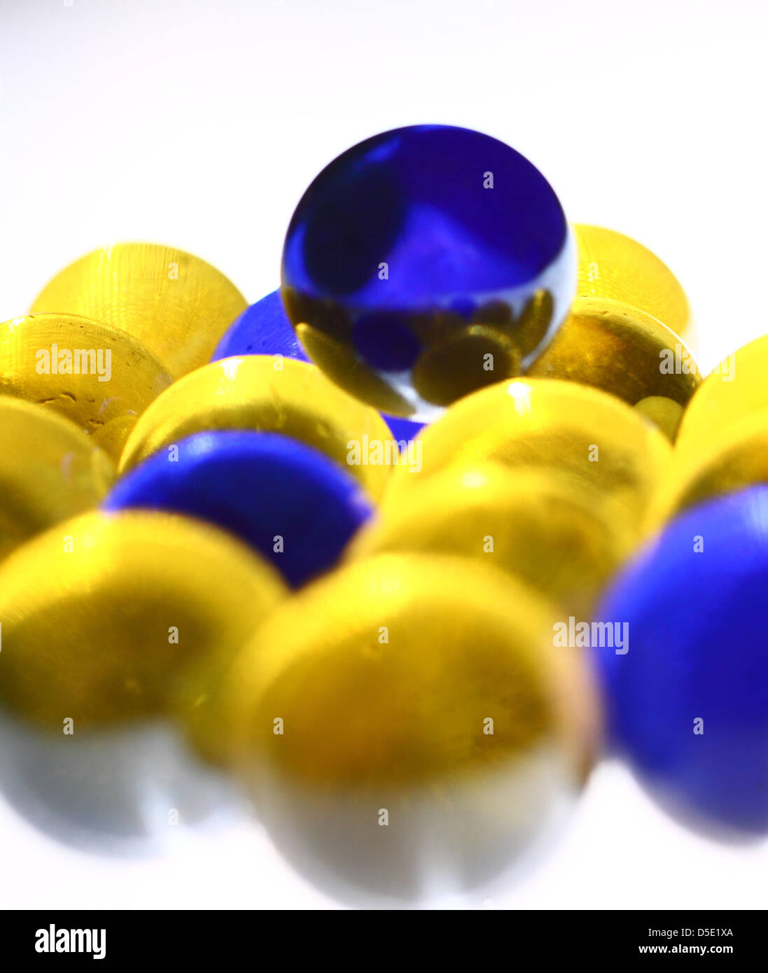 Blue and yellow marbles on a white background Stock Photo - Alamy