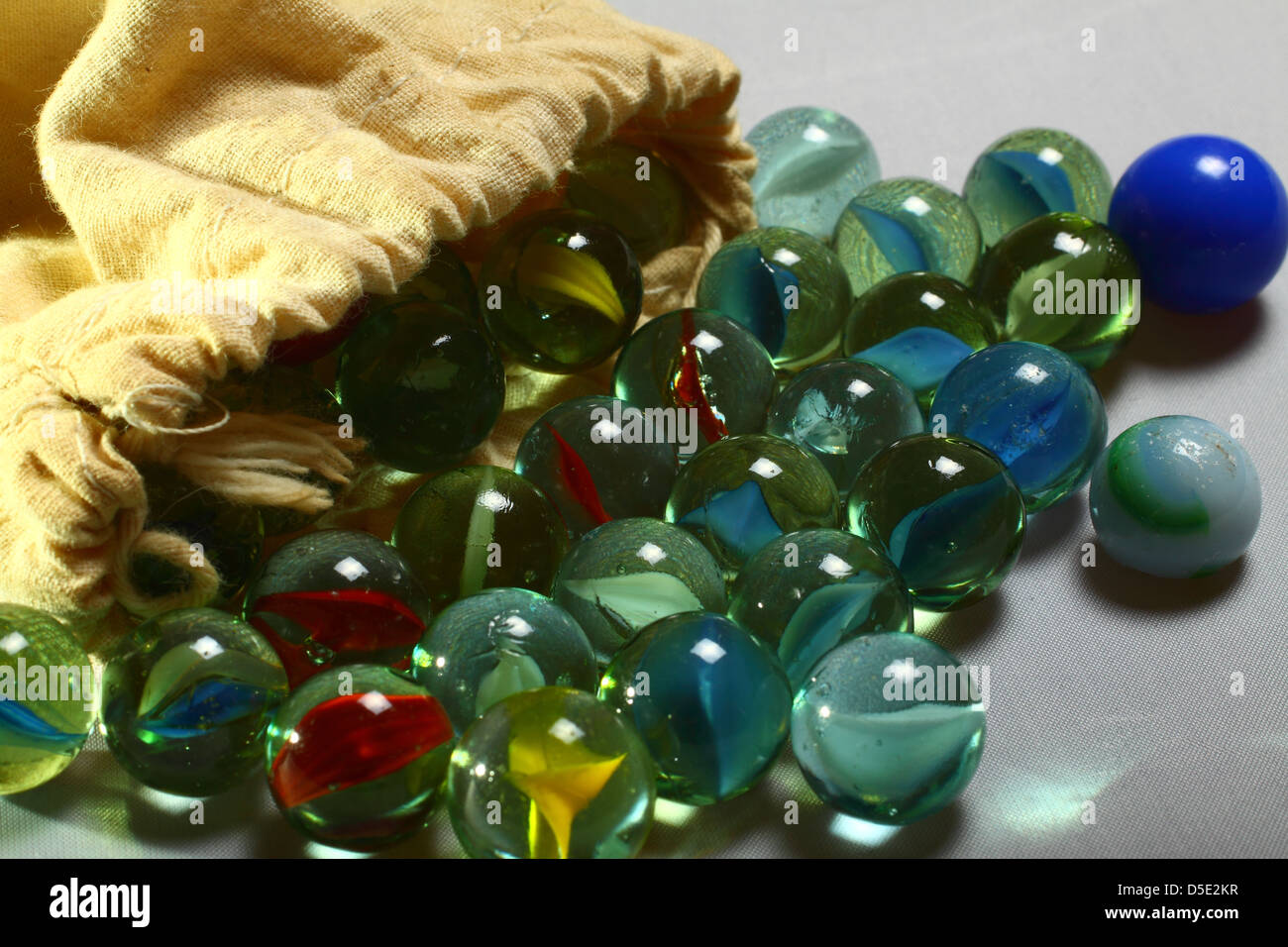 Marbles spilling out of drawstring bag Stock Photo - Alamy