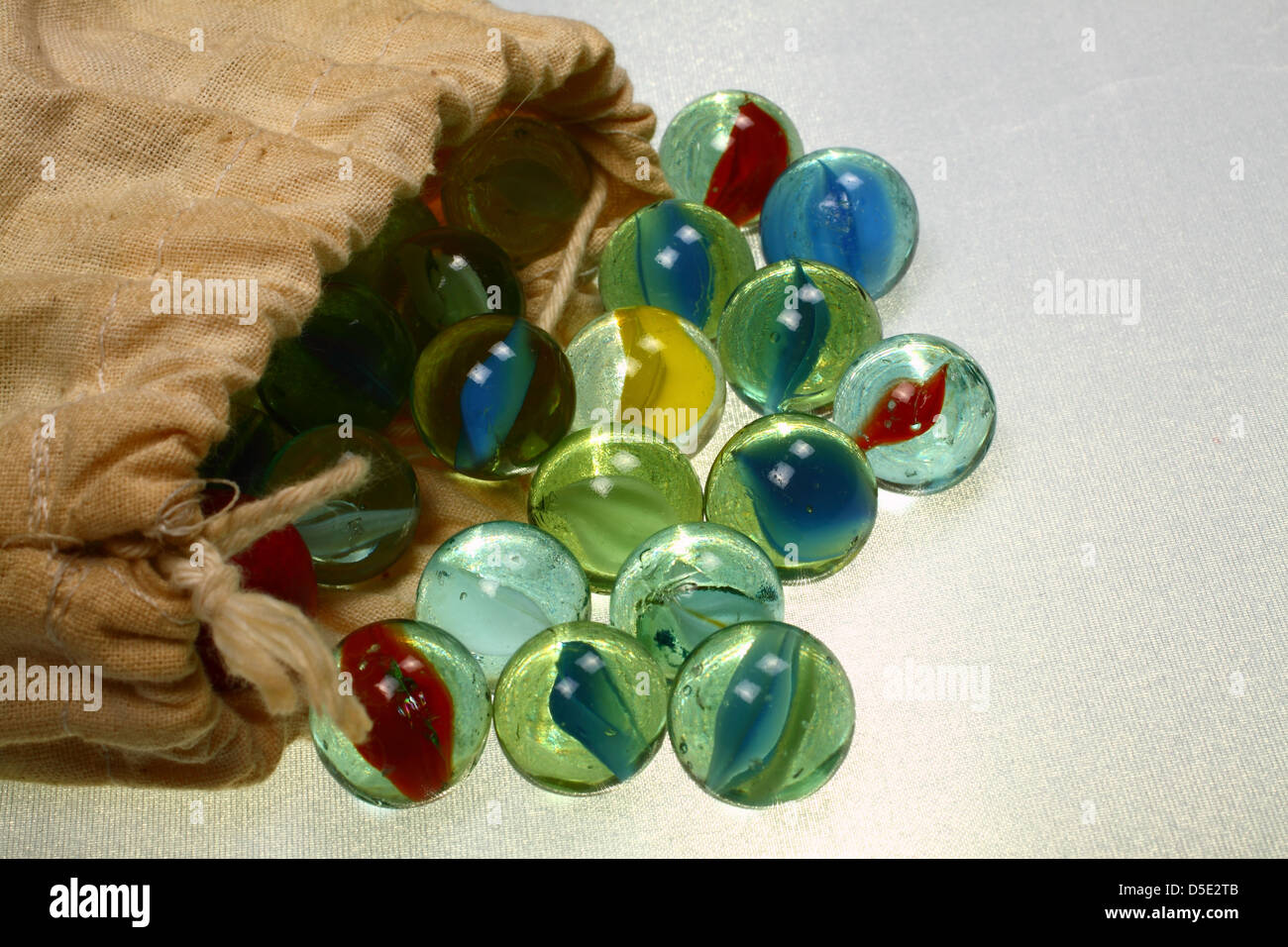 Marbles spilling out of drawstring bag Stock Photo - Alamy