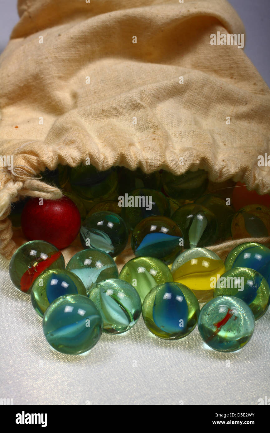 Marbles spilling out of drawstring bag Stock Photo - Alamy