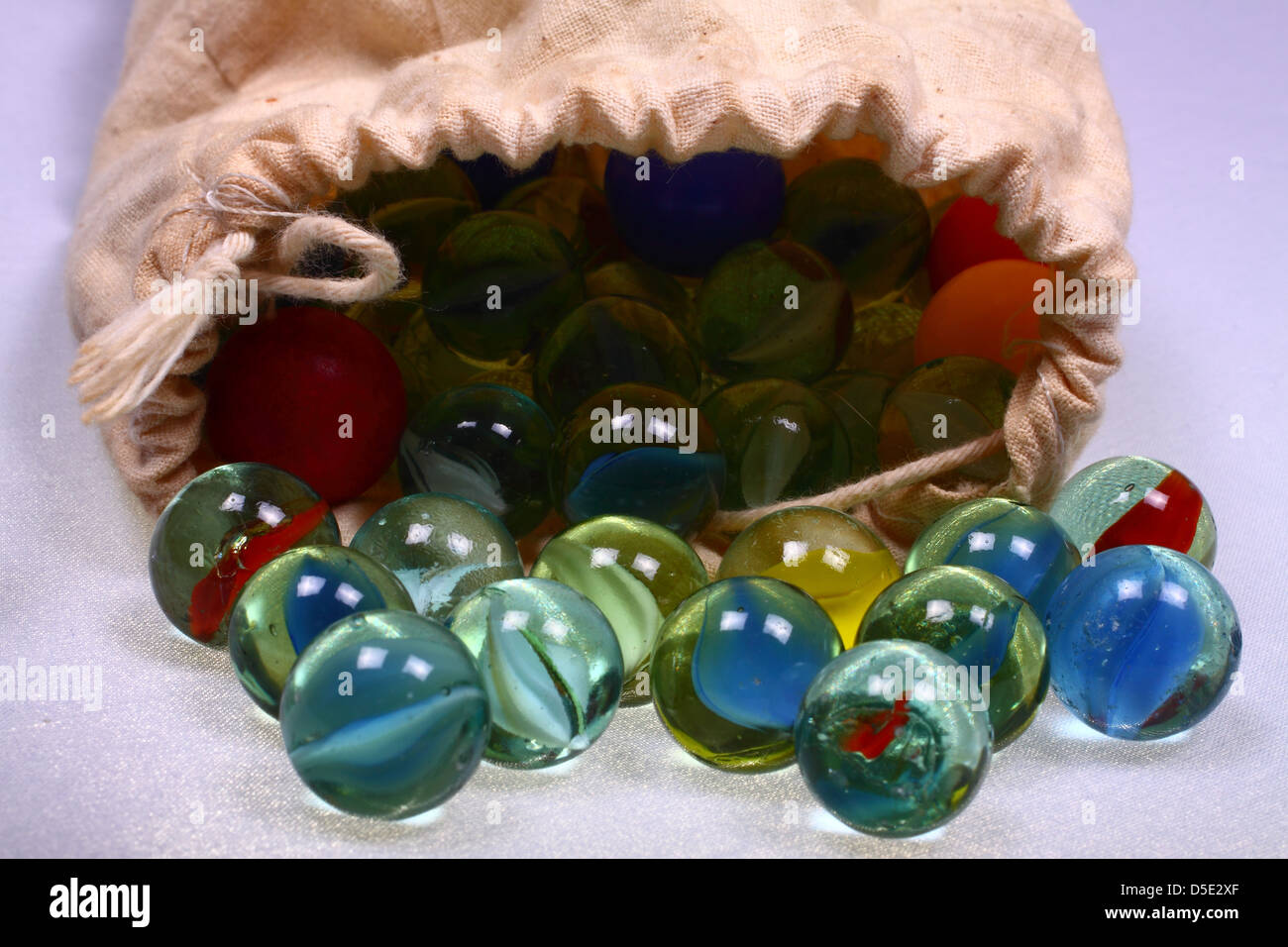 Marbles spilling out of drawstring bag Stock Photo - Alamy