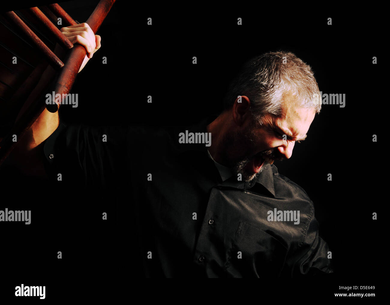 Angry Man Throwing Chair in Fit of Rage Stock Photo - Alamy