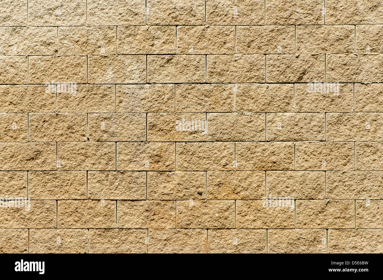 Wall built with blocks of ocher color. background Stock Photo - Alamy