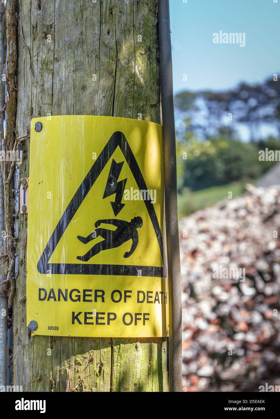 A yellow "Danger of Death" "Keep Off" warning sign typical in the UK ...