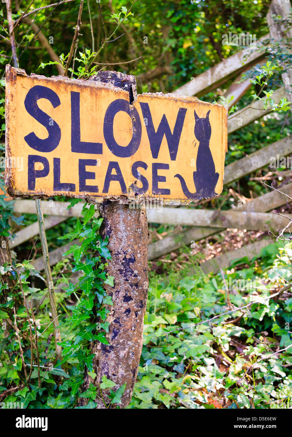 By a farm gate, a homemade road sign asking drivers to slow down please ...