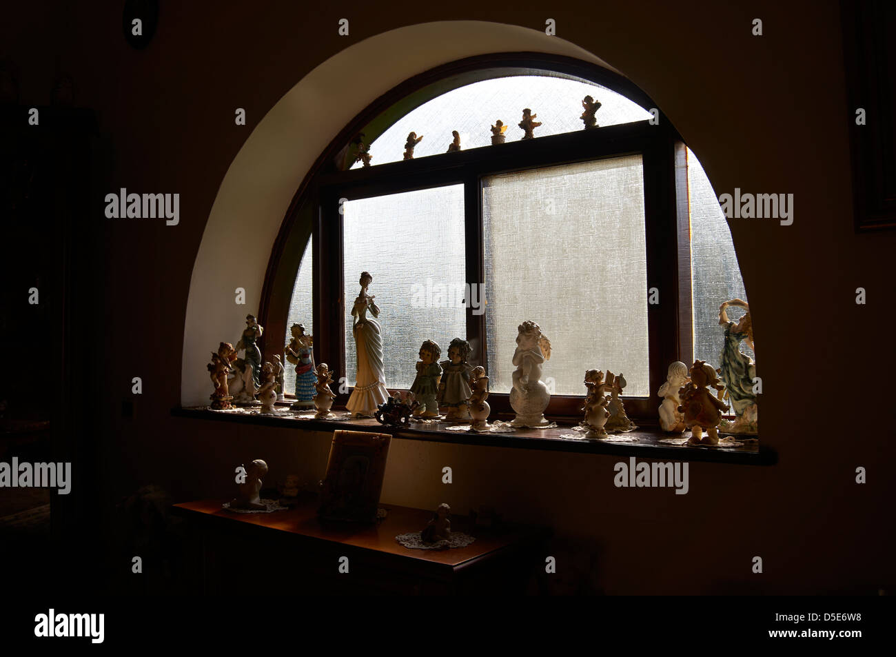 Round window with back lighted statues Stock Photo - Alamy