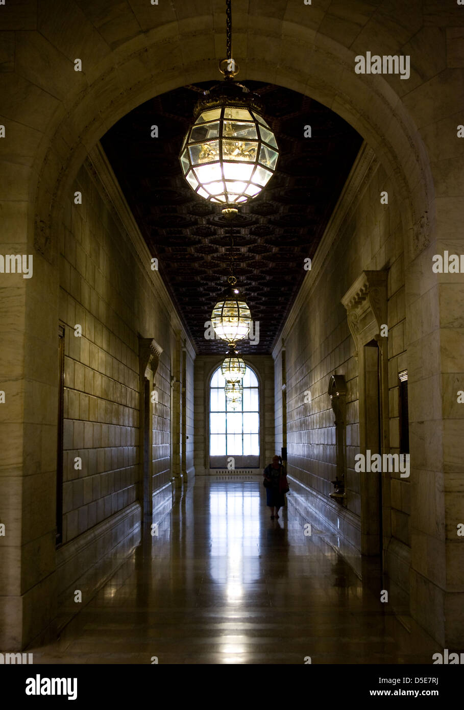 An old stone corridor in New York Public Library with large chandeliers ...