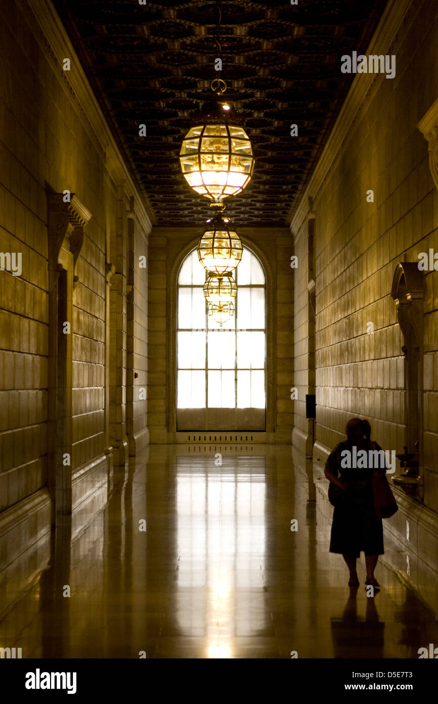 An old stone corridor in New York Public Library with large chandeliers ...