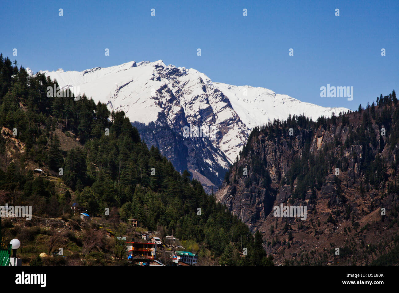 Town with snow covered mountains in the background, Manali, Himachal ...