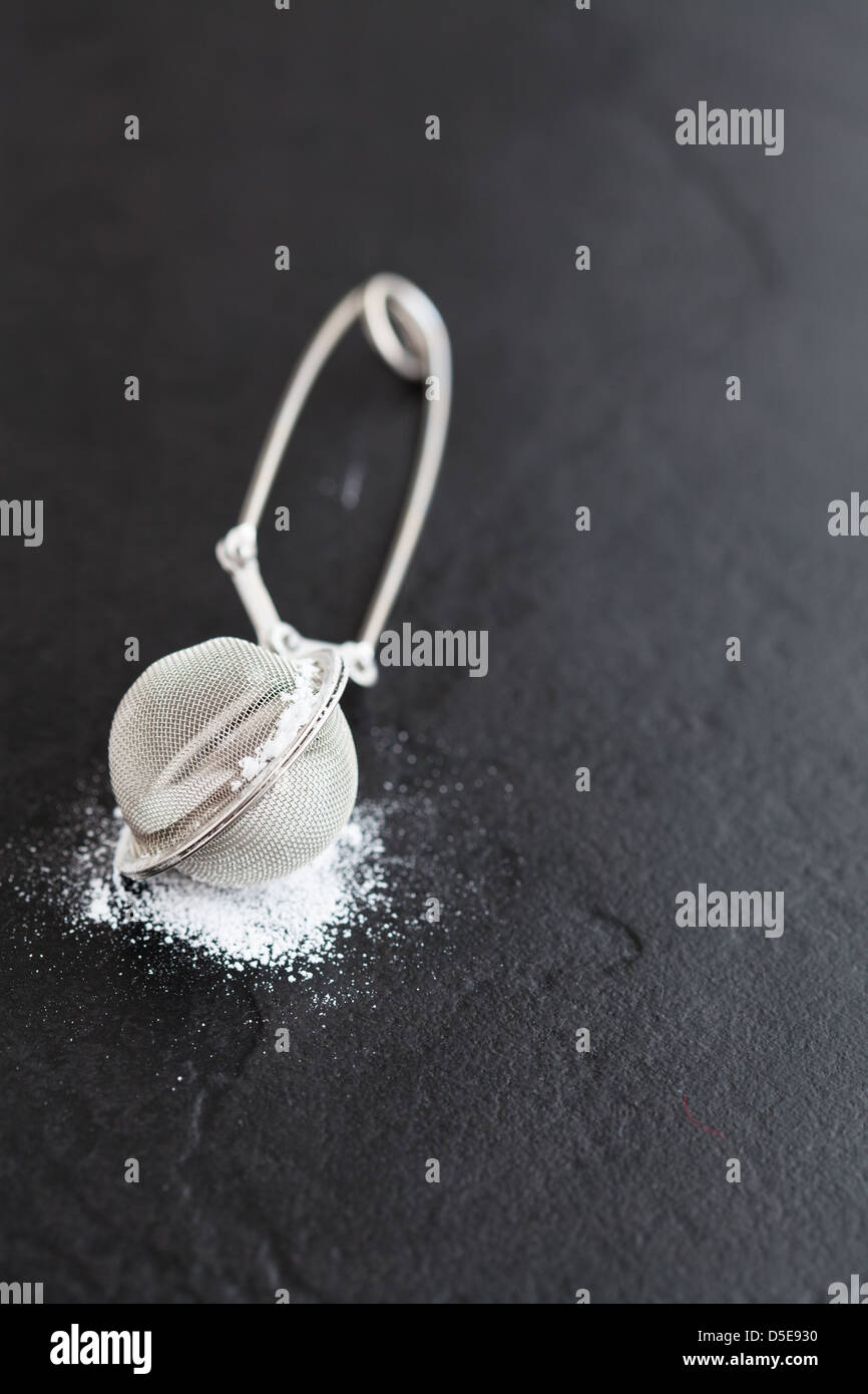 Closeup of sieve and icing sugar on dark textured background Stock ...