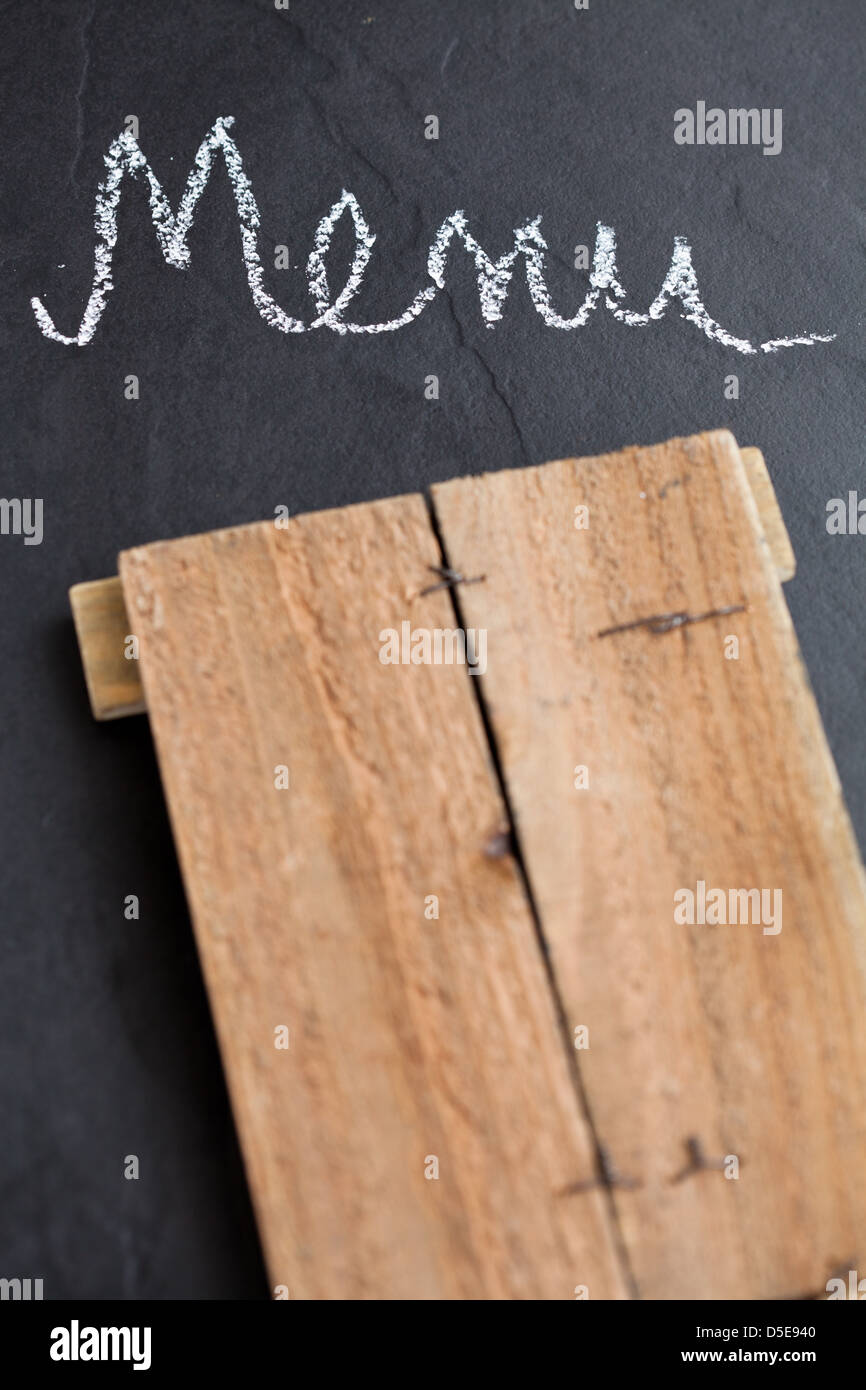 Closeup of wooden board and word menu written in chalk on dark ...