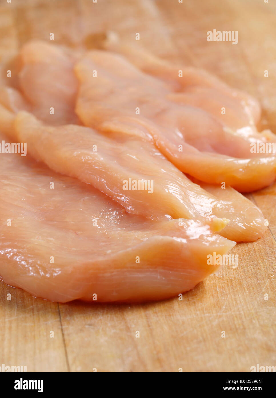 Chicken fillets on a wooden board in vertical composition Stock Photo ...