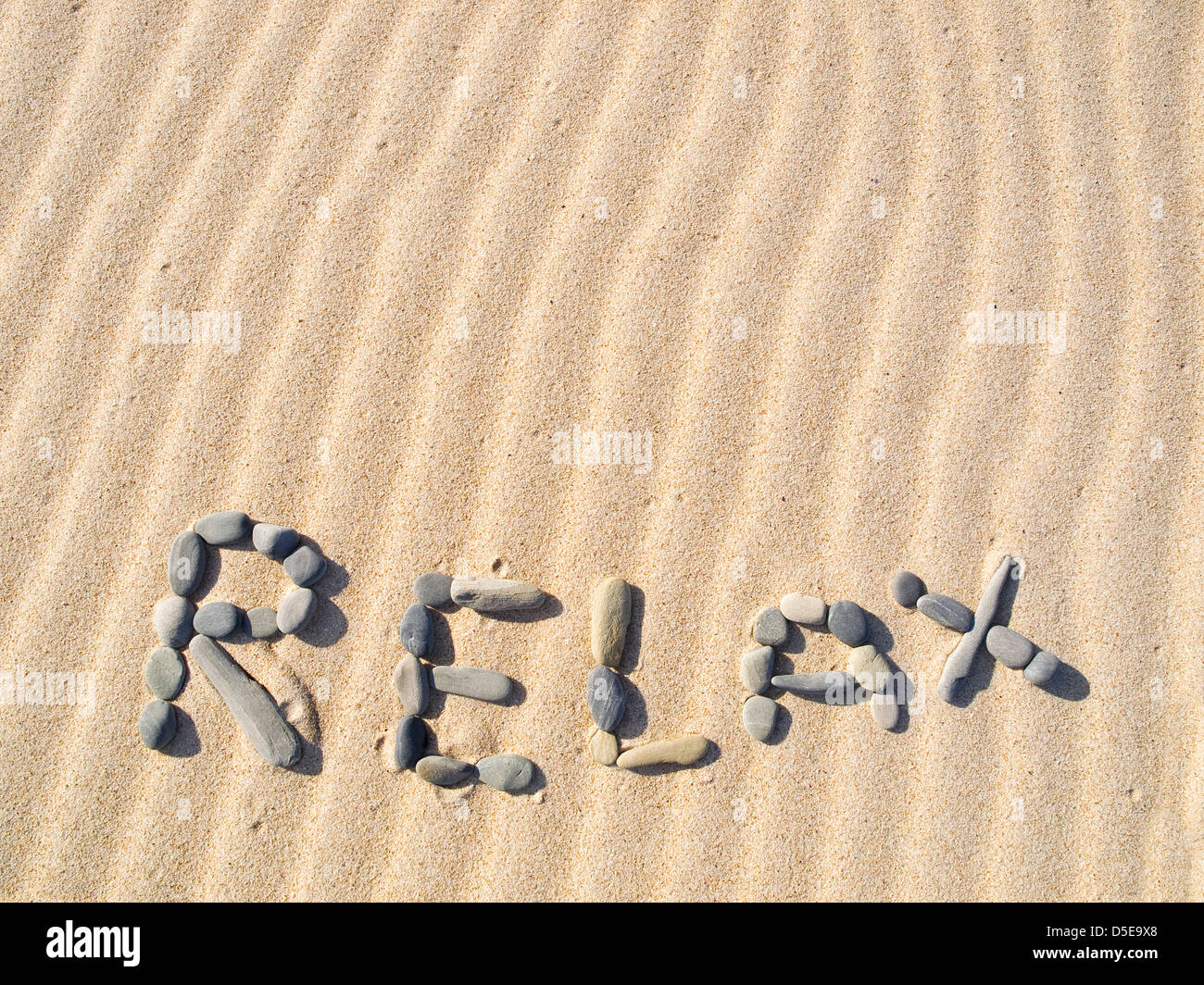 Word relax written in sand on a sunny day Stock Photo - Alamy