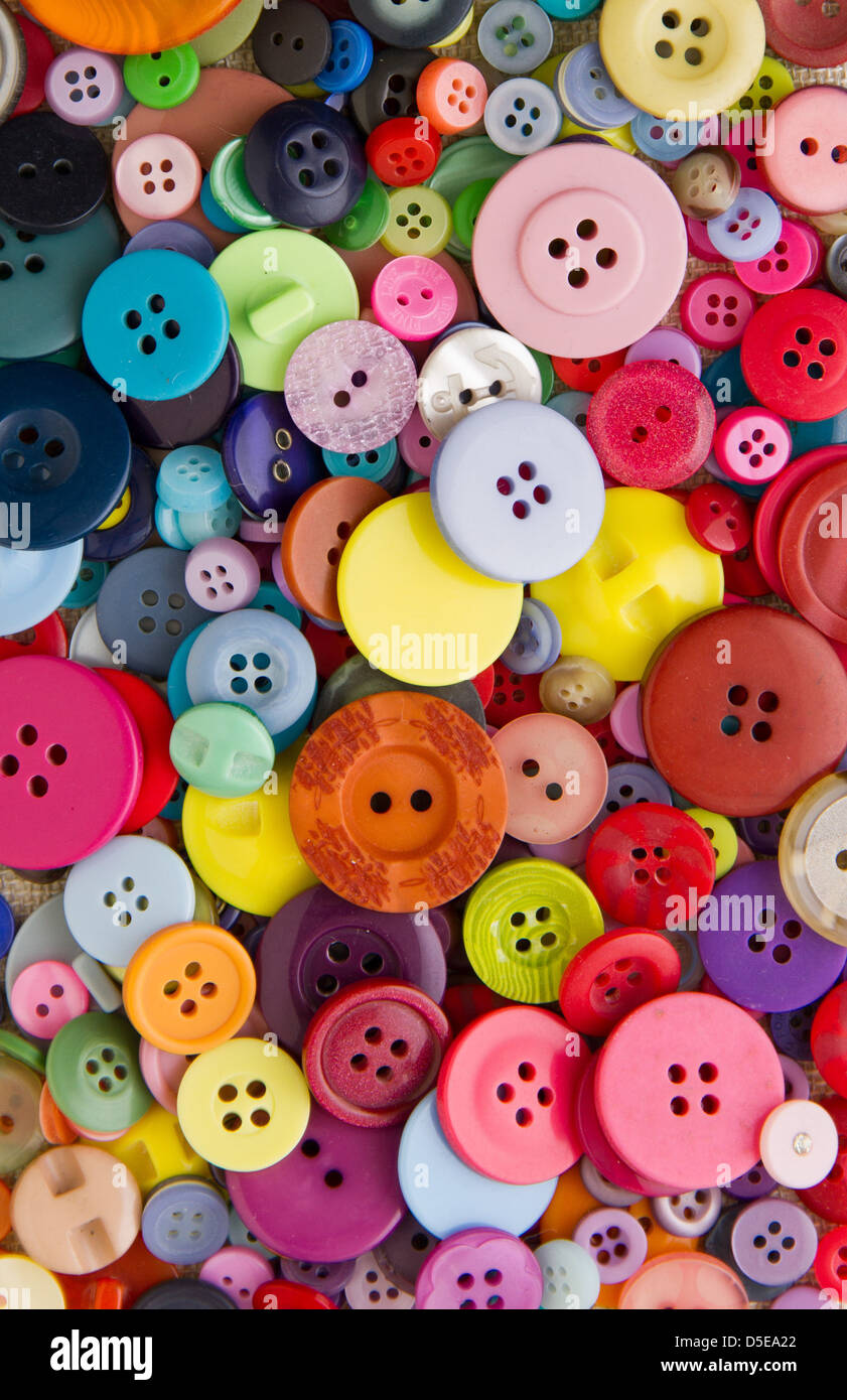 Many mixed, brightly coloured sewing or clothing buttons, filling the ...