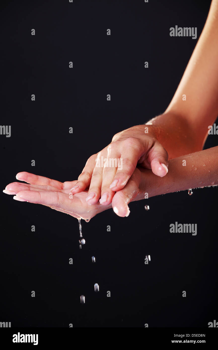 Water falling on female hands, over black background Stock Photo - Alamy